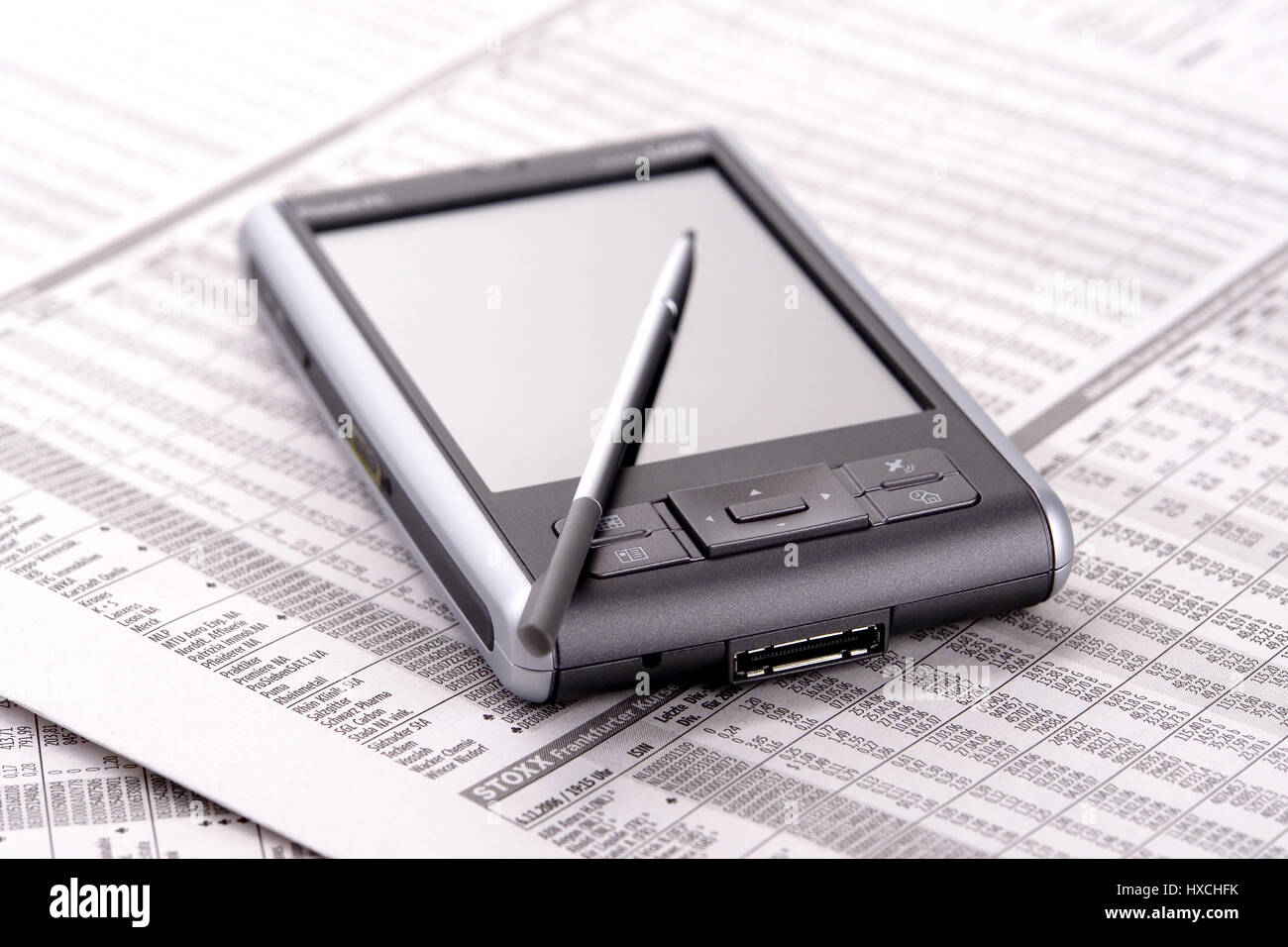 PDA with financial paper, PDA mit Boersenzeitung Stock Photo - Alamy
