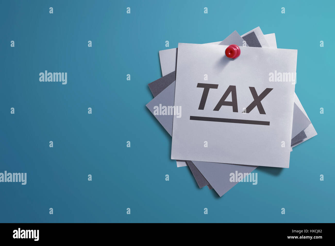 White note paper and written Tax for reminder on blue background Stock ...