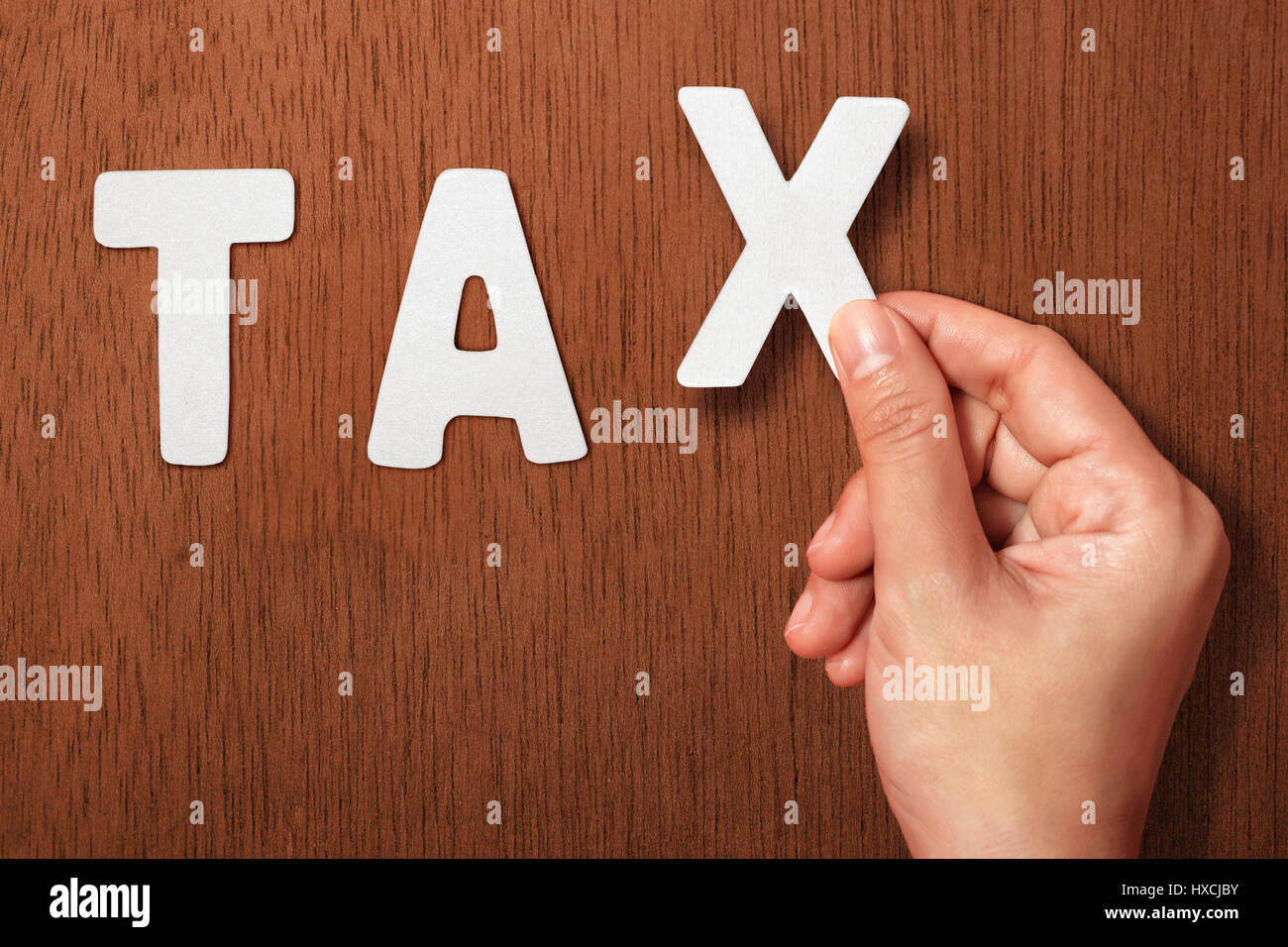 People hand holding Tax alphabet on wooden background Stock Photo - Alamy