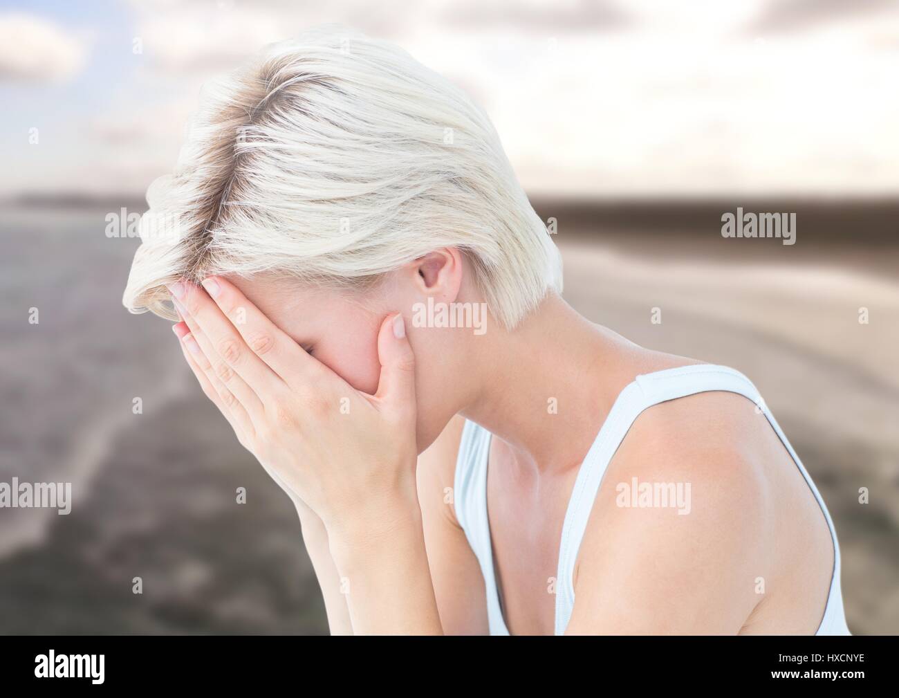 Digital composite of Sad woman with face in hands against sea landscape ...