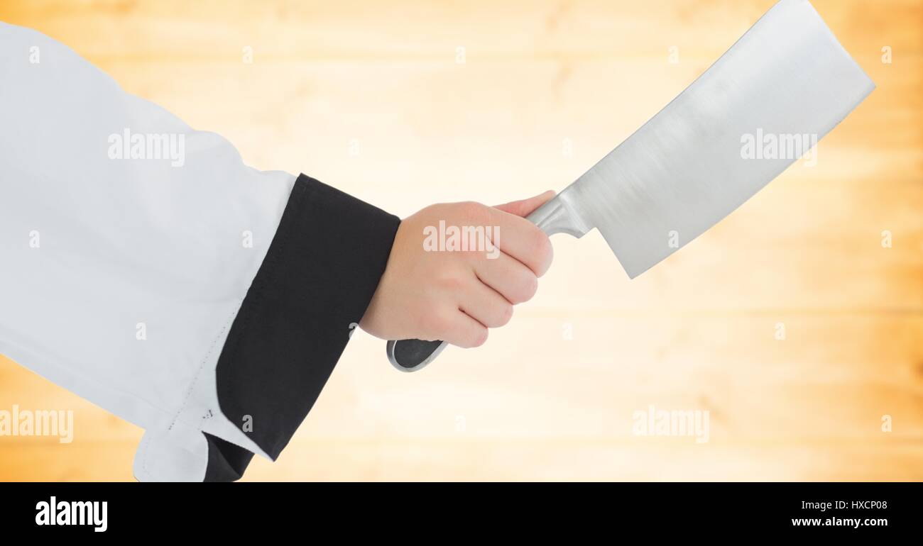 Digital composite of Chef hand with cleaver against blurry yellow wood ...