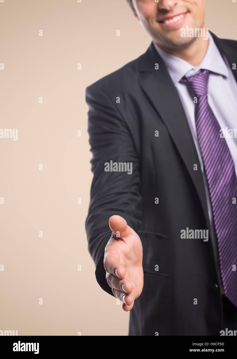 Digital composite of Business man with hand outstretched against cream ...