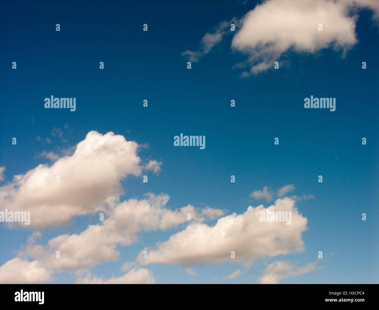 Some white crips clouds hanging over a field on a sunny day Stock Photo ...