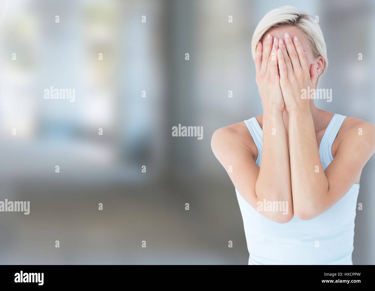 Digital composite of Sad woman grief with face in hands against blurred ...