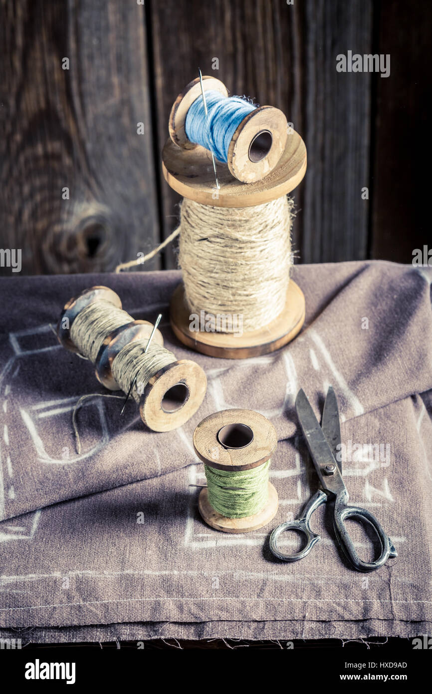 Sewing table with needle, threads and scissors Stock Photo - Alamy