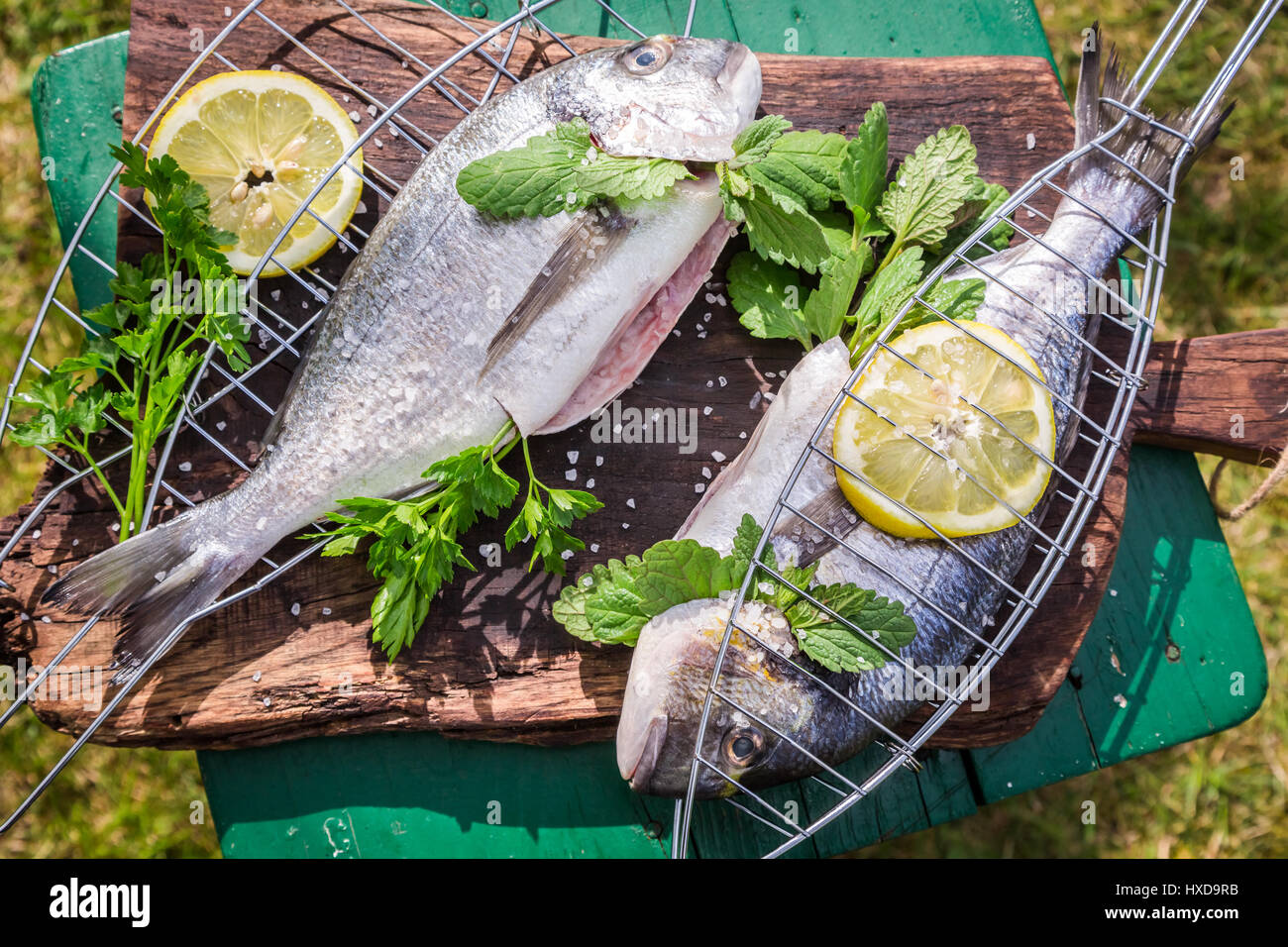 Grilling fresh fish with lemon and herbs Stock Photo - Alamy