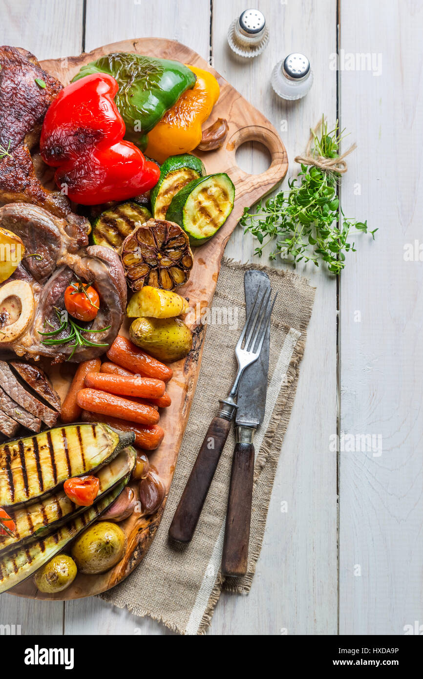 Roasted steak and vegetables with herbs on white table Stock Photo - Alamy