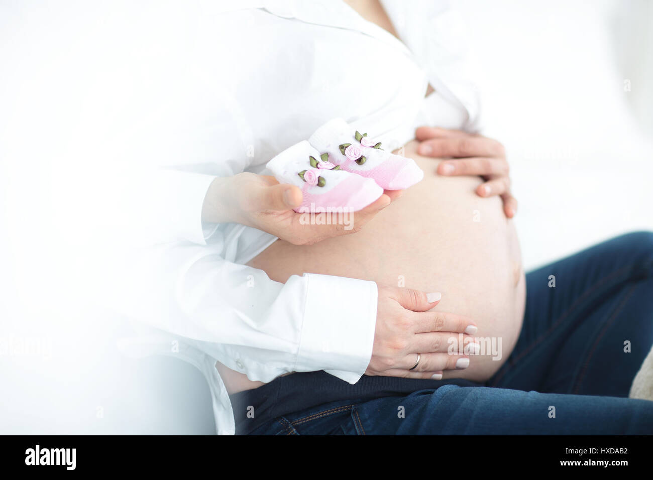 Pregnant woman hugging her stomach at home Stock Photo - Alamy