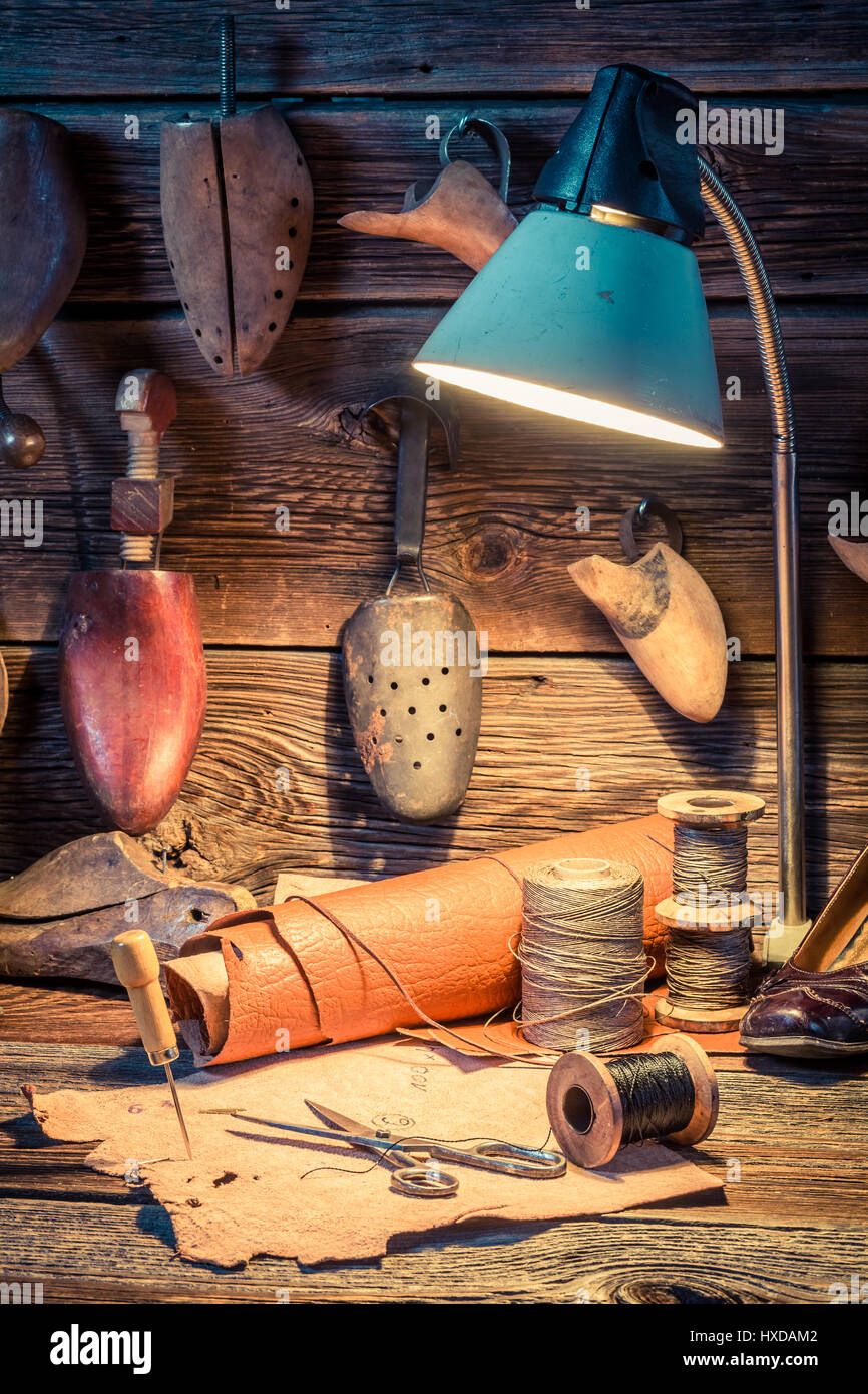 Vintage cobbler workshop with shoes, laces and tools Stock Photo - Alamy