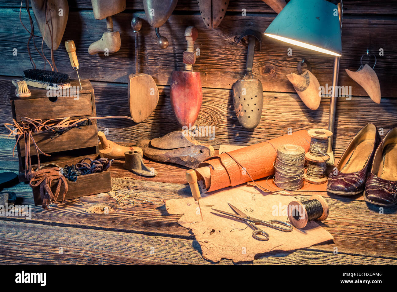 Vintage cobbler workshop with tools, shoes and leather Stock Photo - Alamy