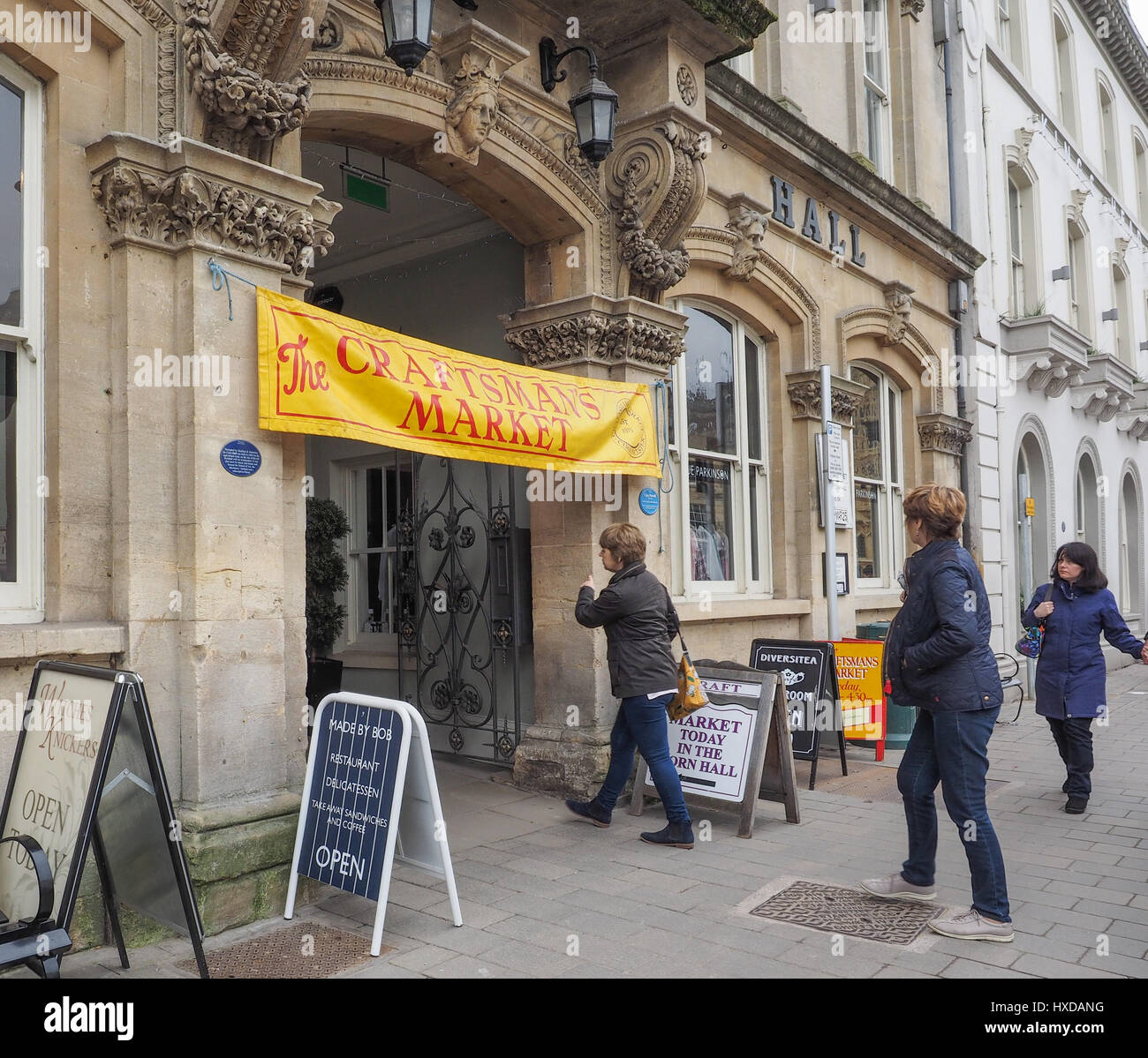 a view of shoppers walking to the Corn Hall craft fair with a banner ...