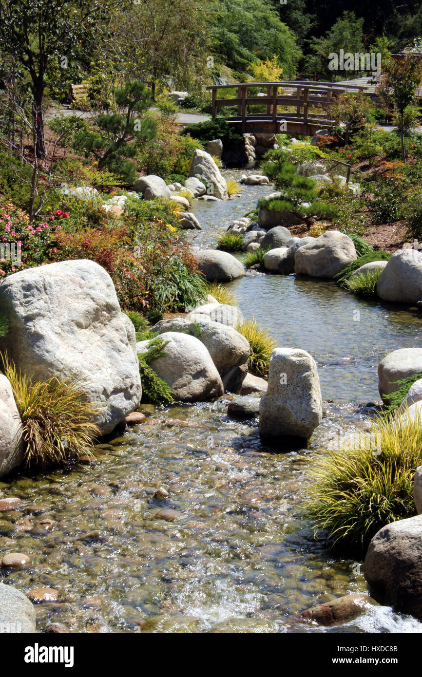 Close up of a beautiful, shallow stream running over rocks in a garden ...