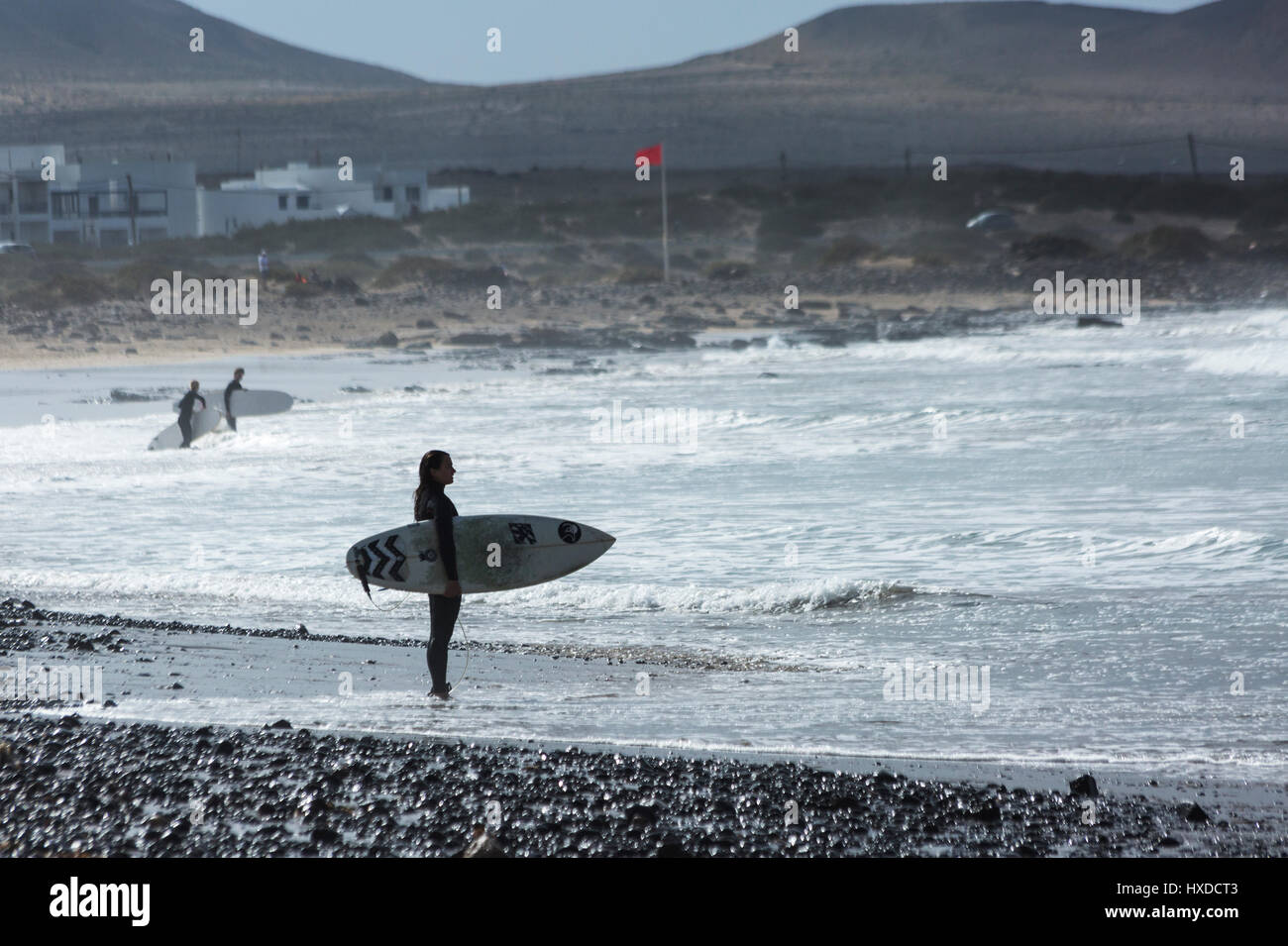 Girl surfer standing with surf board on Famara beach Lanzarote Stock ...