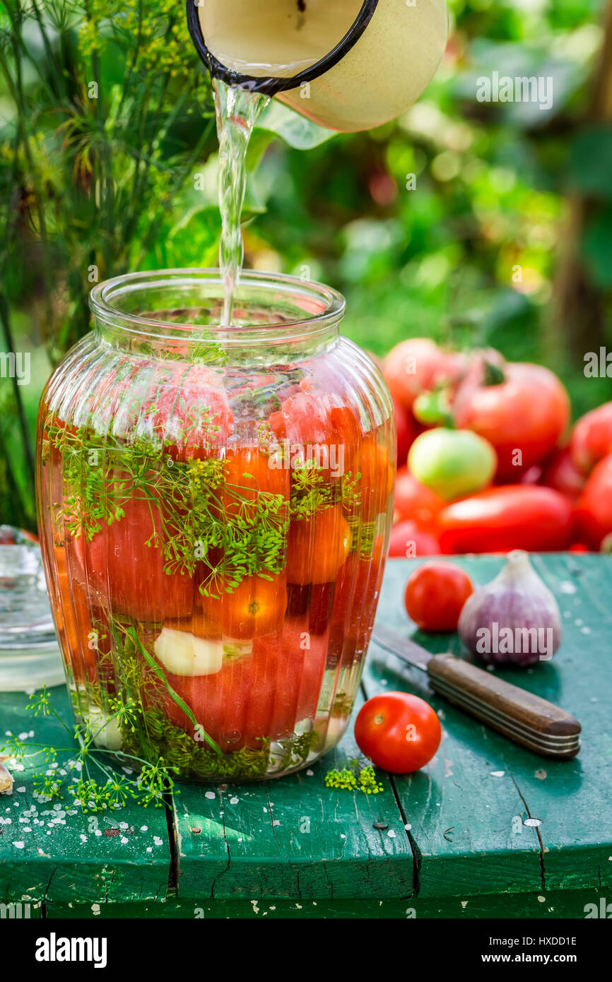 Pouring water into pickled tomatoes Stock Photo - Alamy