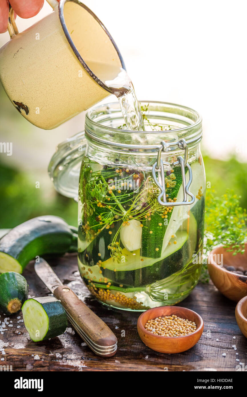 Pouring water into jar with zucchini and spices Stock Photo - Alamy