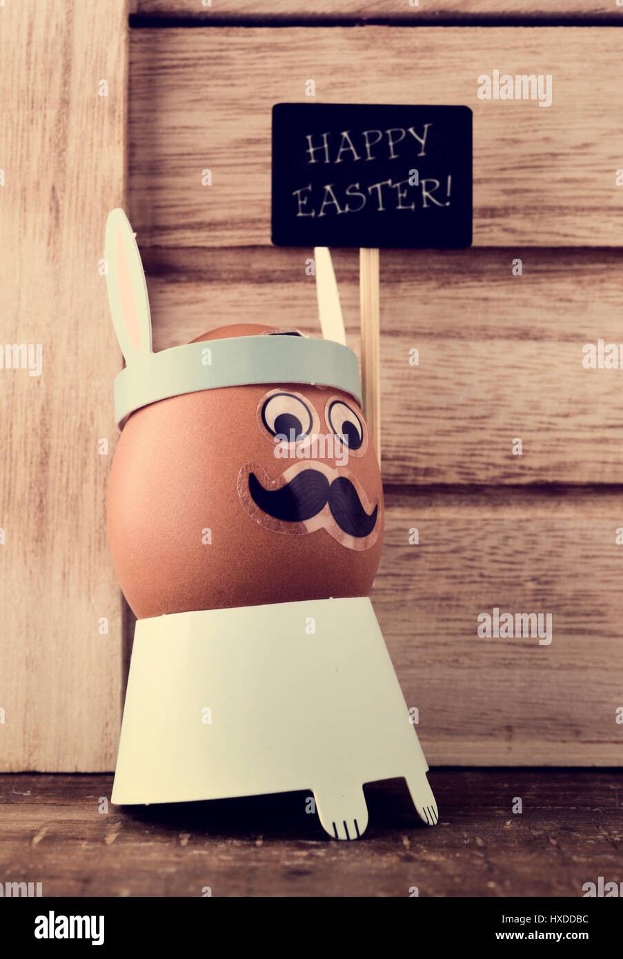 closeup of an easter egg decorated with eyes and a mustache, holding a ...