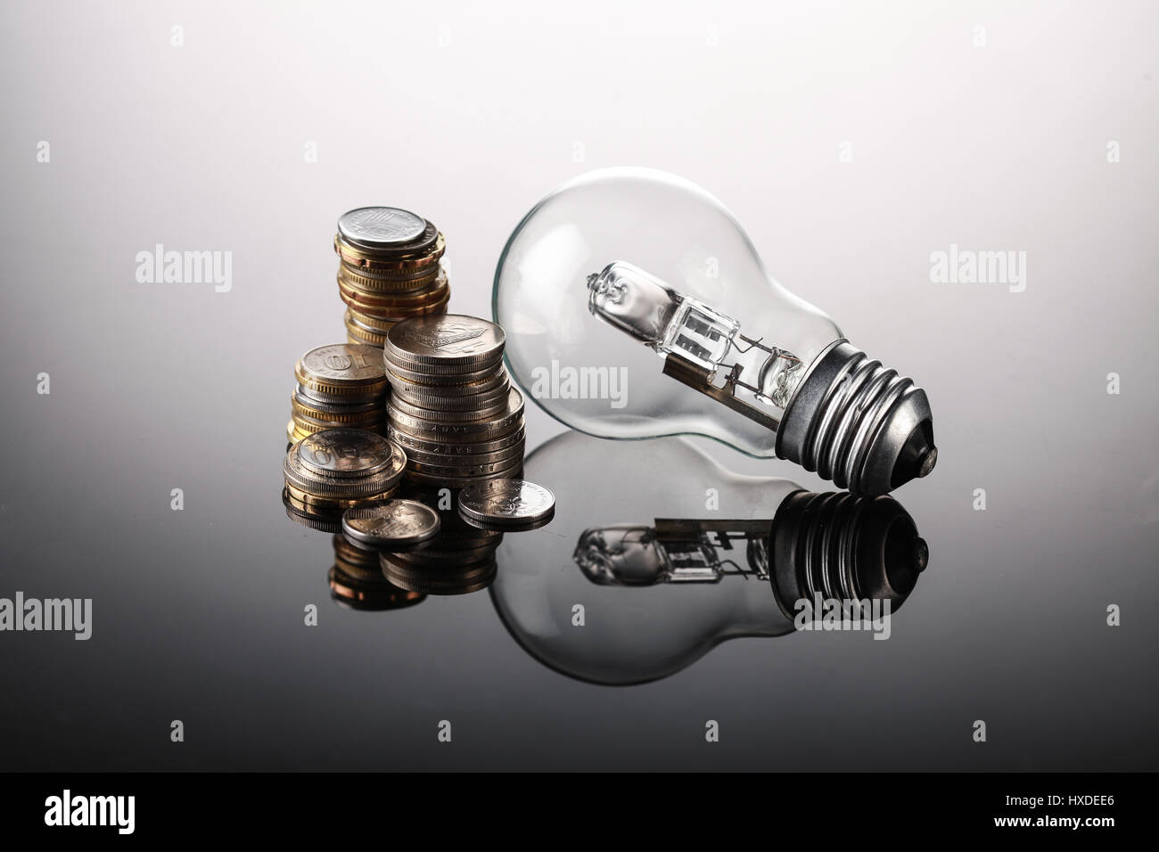 light bulb with stack of coins concept Stock Photo - Alamy
