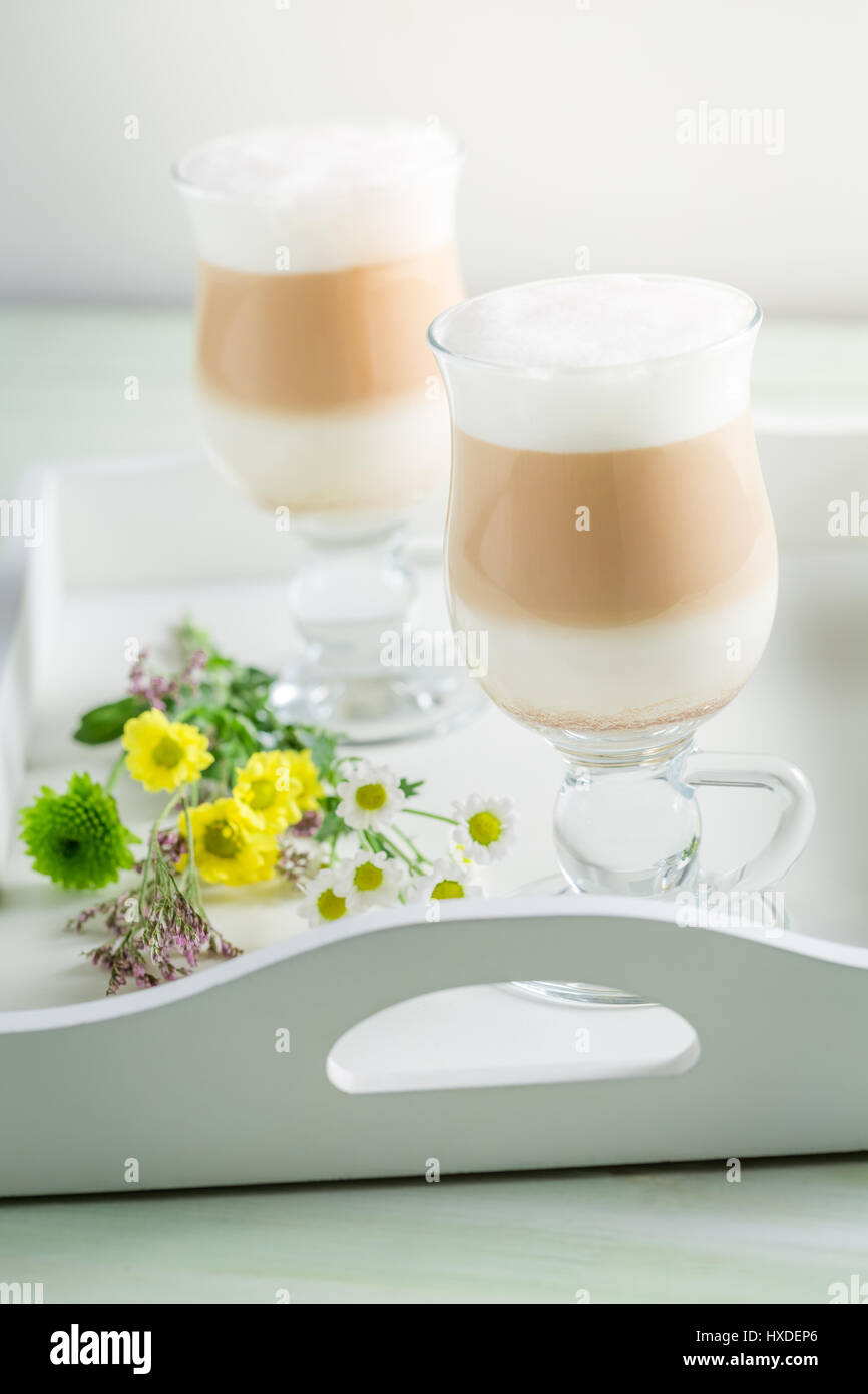Two latte coffee with spring flowers Stock Photo - Alamy
