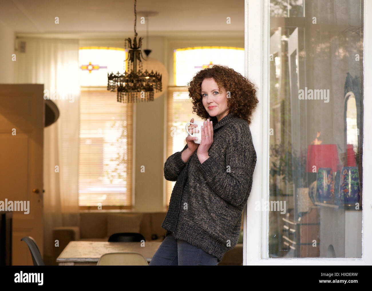 Portrait of an attractive middle aged woman standing with cup of tea at home Stock Photo - Alamy