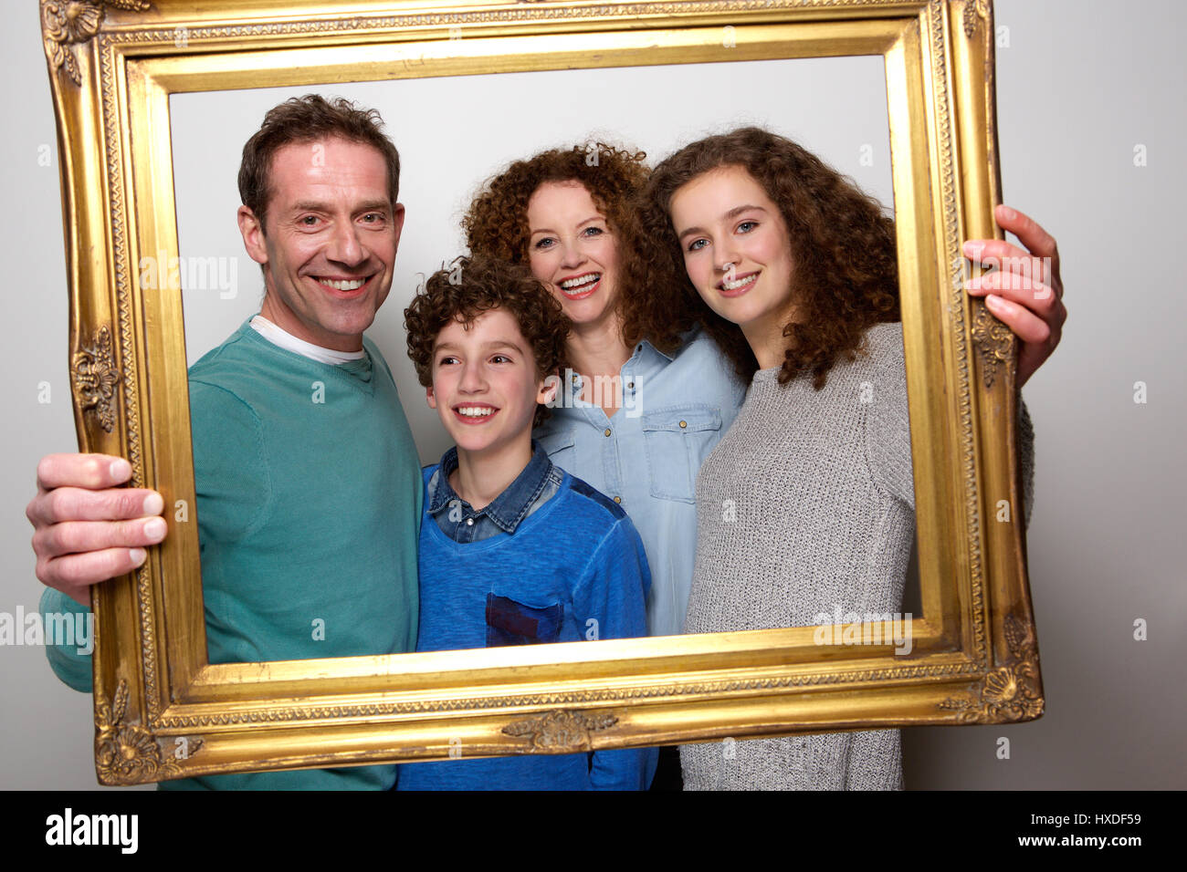 Portrait of a happy family holding picture frame and smiling Stock ...