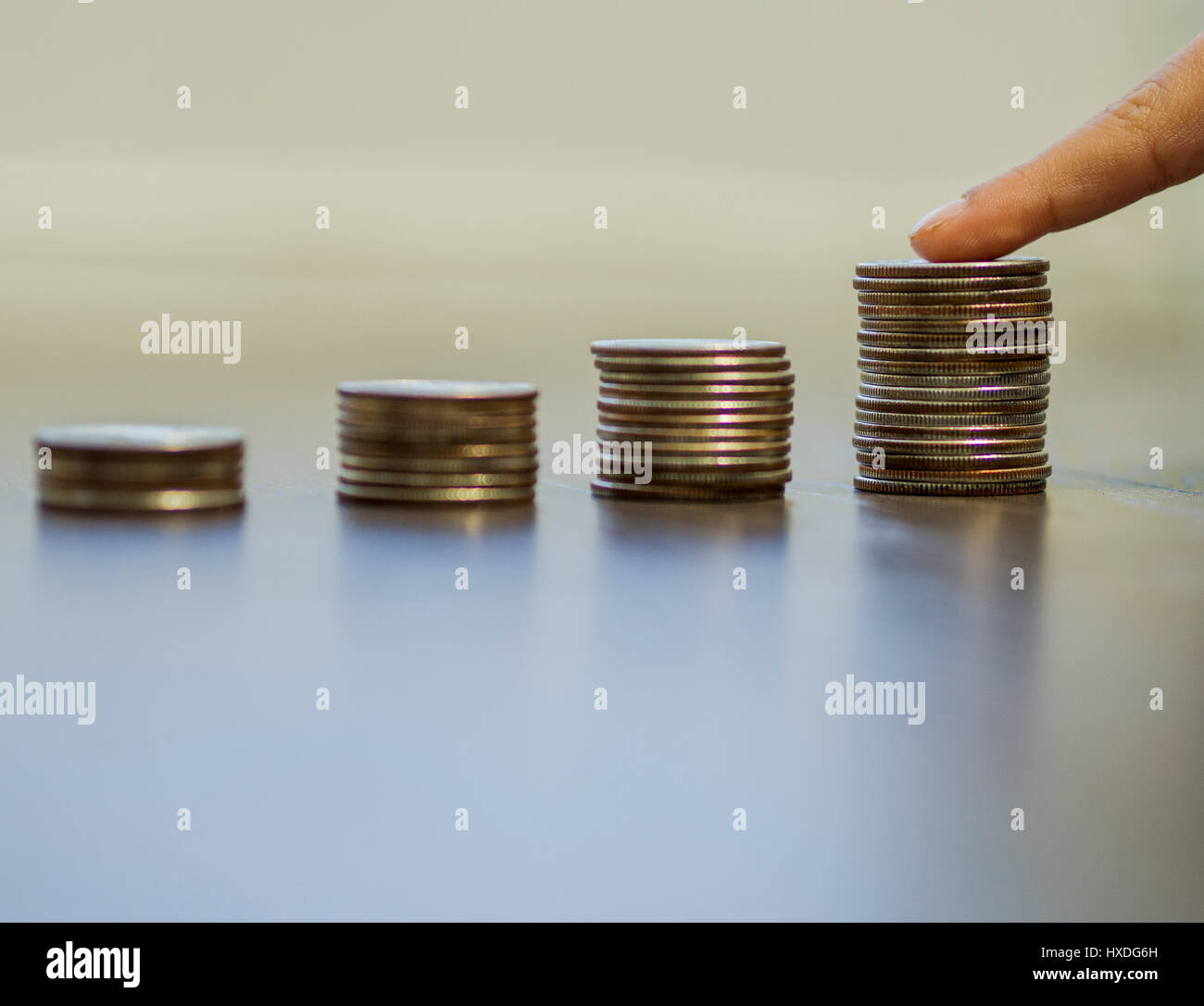 Coins showing Money saving growth with a finger pointing to added ...