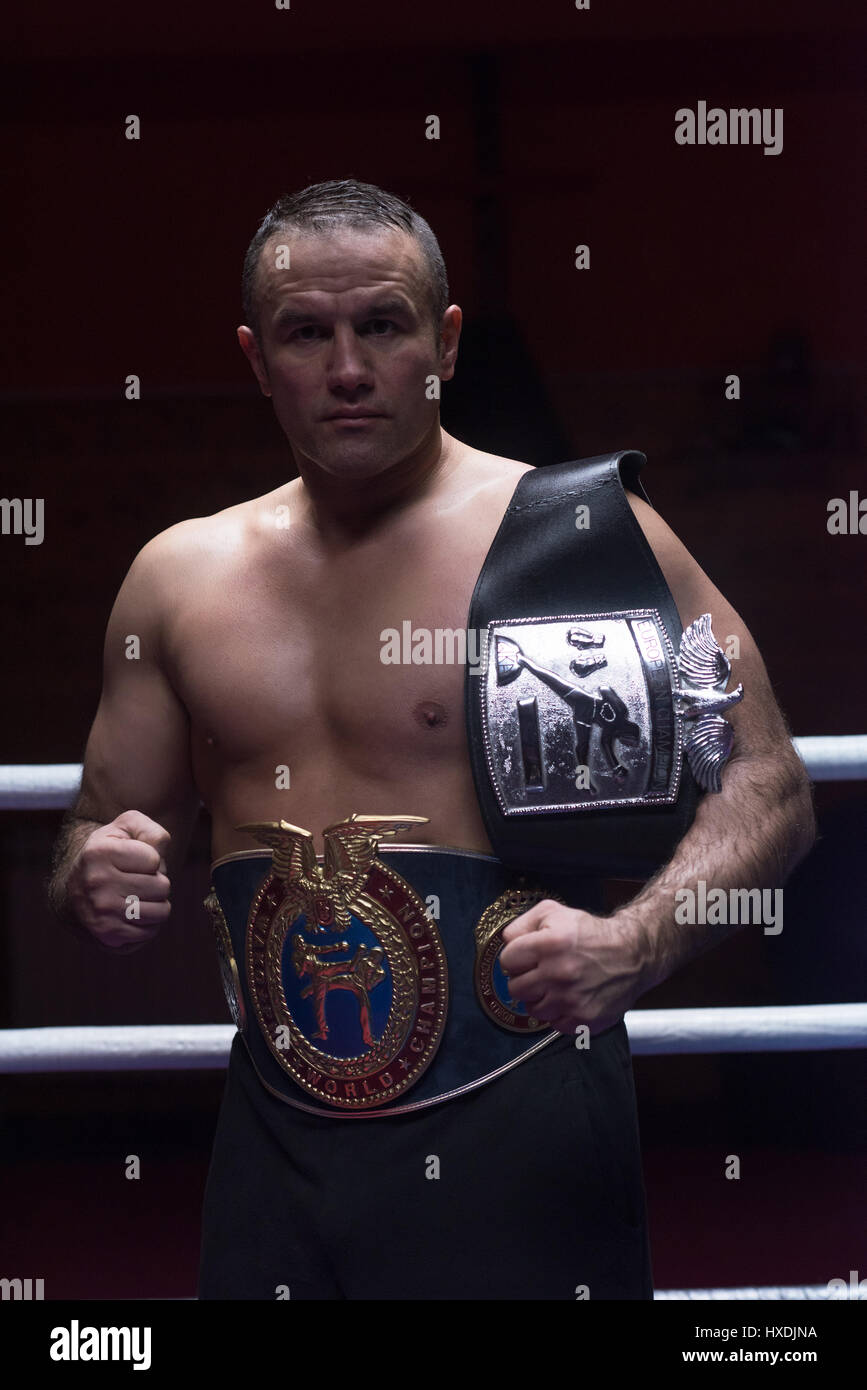 portrait of muscular professional kick boxer with his championship belt ...