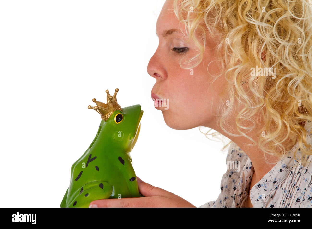 Young woman kissing a frog prince isolated on white background Stock ...
