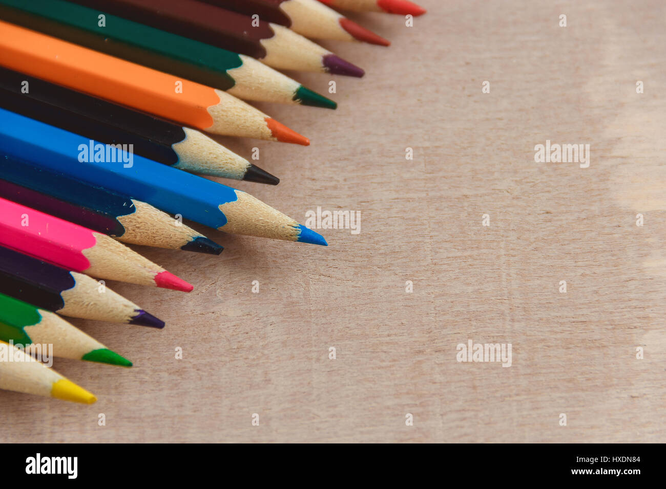 Colour pencils on wooden texture background Stock Photo - Alamy