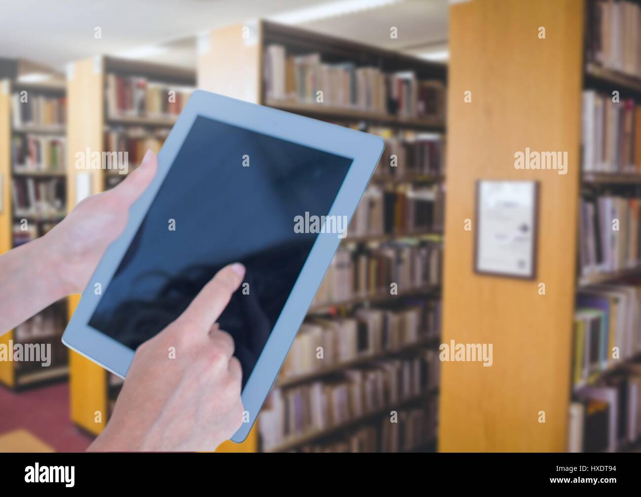 Digital composite of Womans hands touching tablet in Library Stock ...