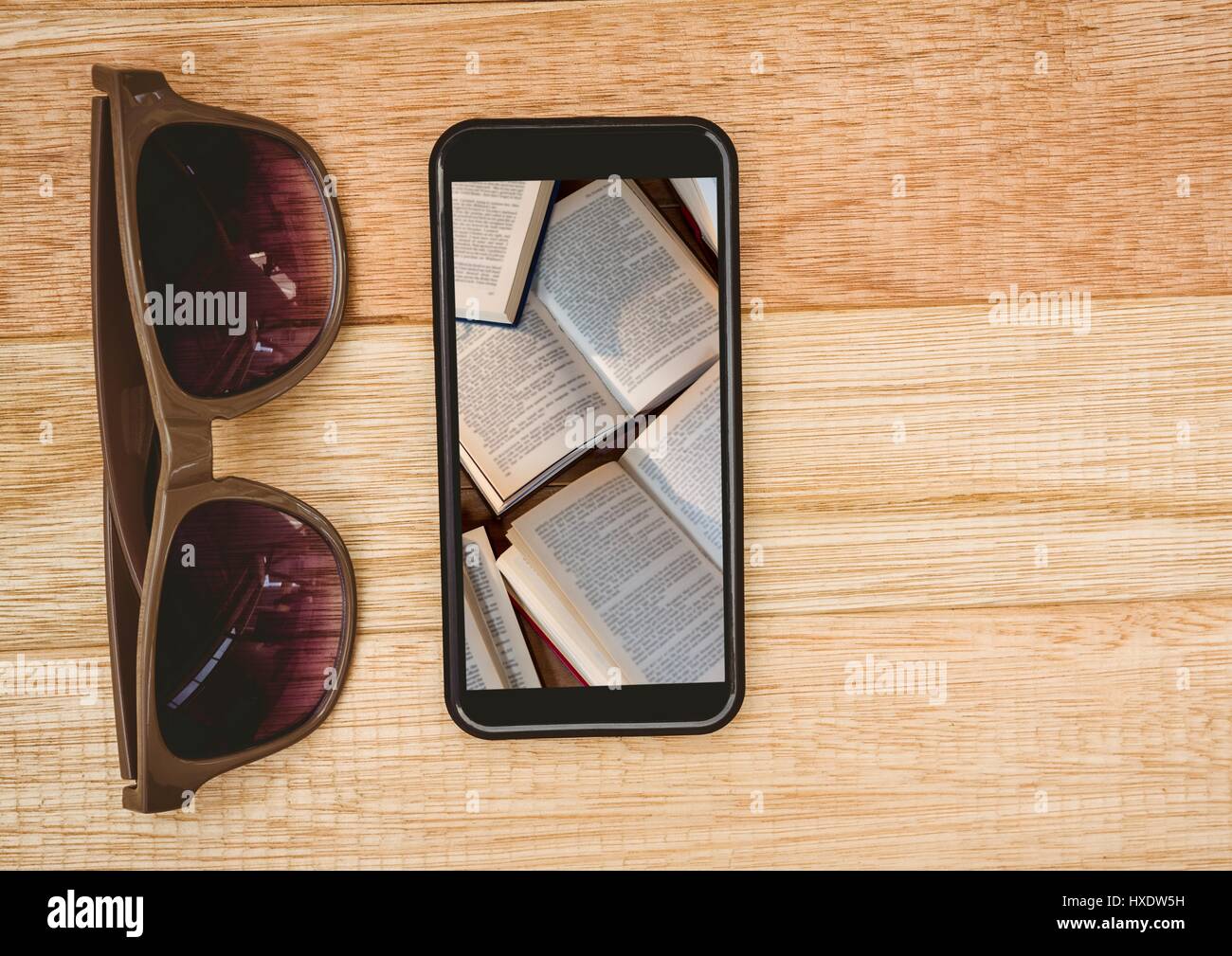 Digital composite of Sunglasses and phone showing open books Stock ...