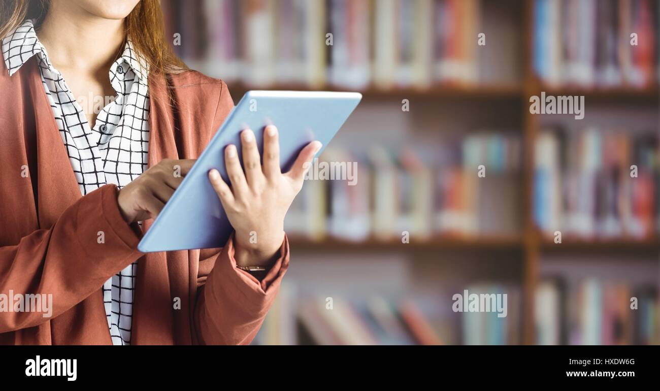 Digital composite of Womans hands on tablet in Library Stock Photo - Alamy