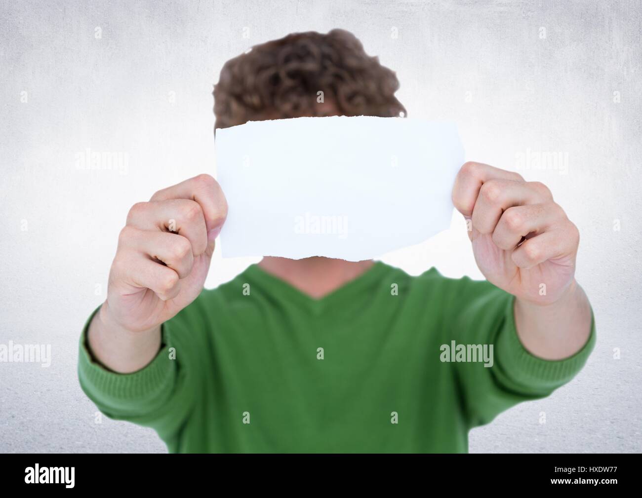 Digital composite of Man holding ripped paper over face against white ...