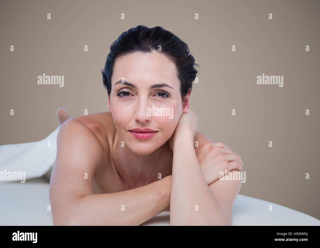 Digital composite of Woman lying on front against brown background ...