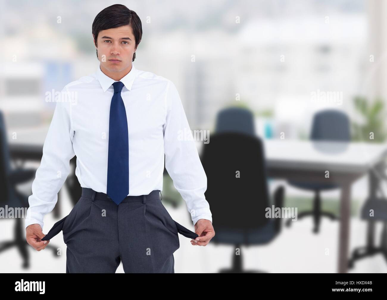 Digital composite of Sad businessman with empty pockets against office ...