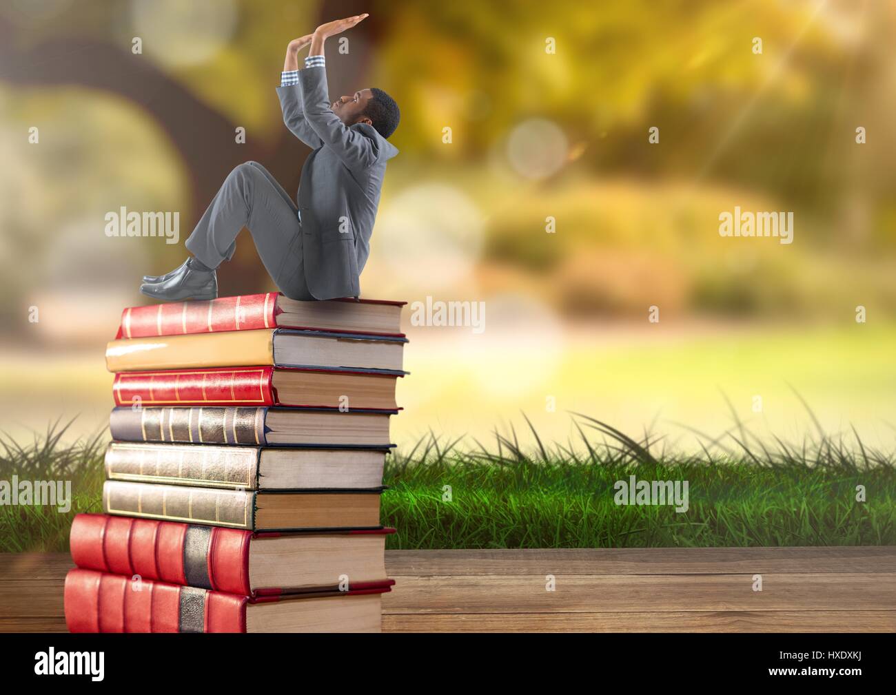 Digital composite of Businessman sitting on Books stacked by greenery ...