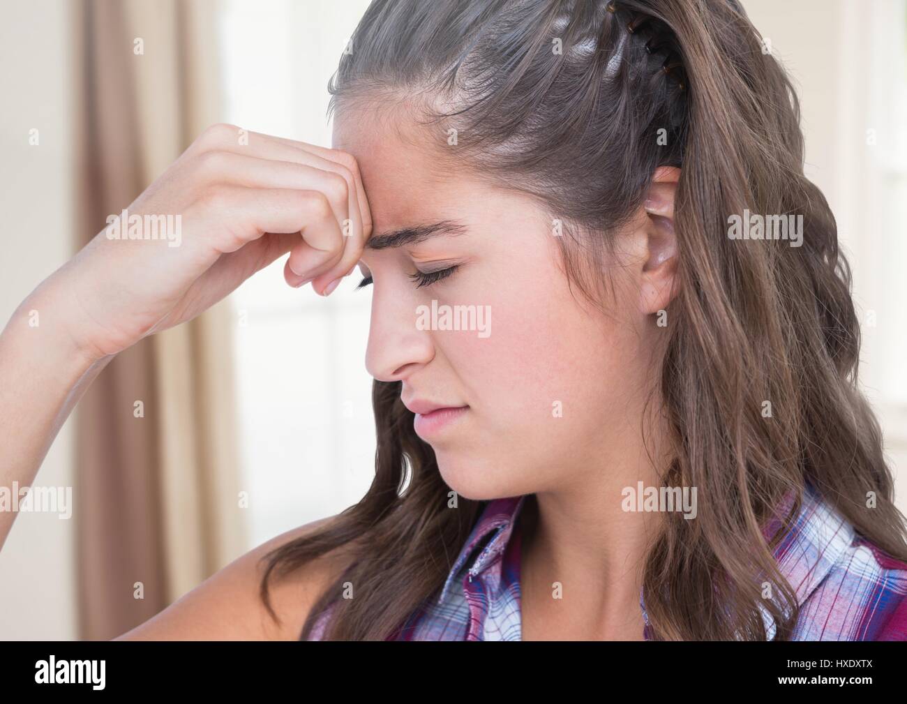 Digital composite of Stressed girl with sore head by window Stock Photo ...
