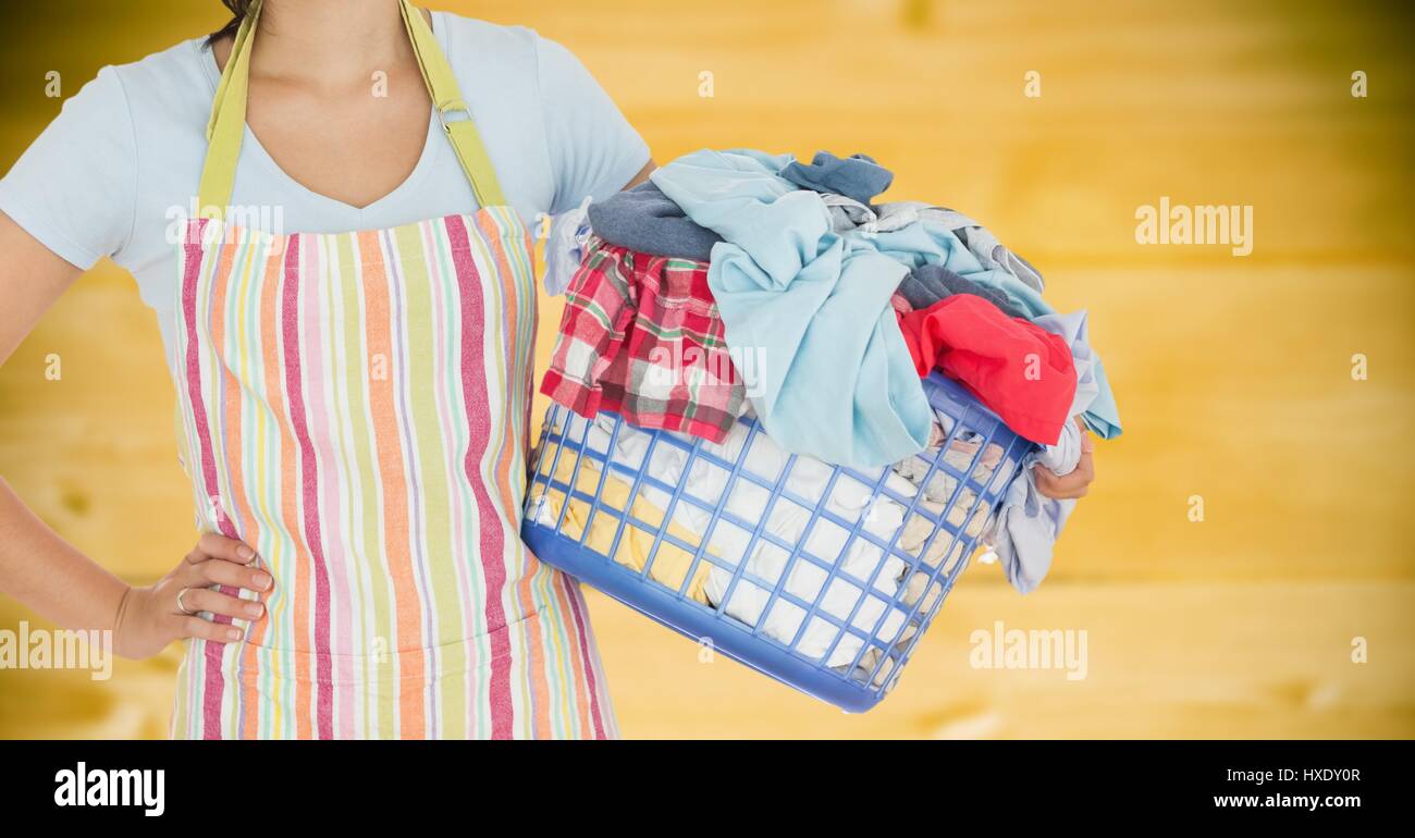 Digital composite of Woman in apron with laundry against blurry yellow ...