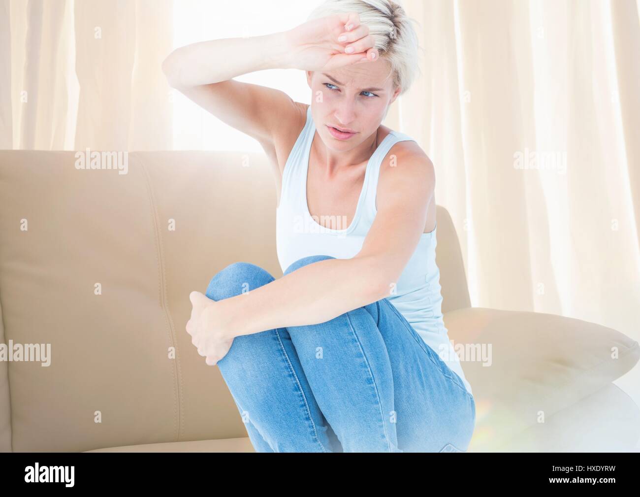 Digital composite of Sad distressed afraid woman crouched near window ...