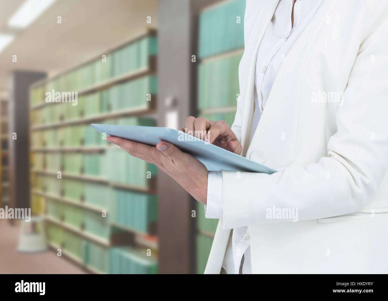 Digital composite of Womans tablets holding tablet in Library Stock ...