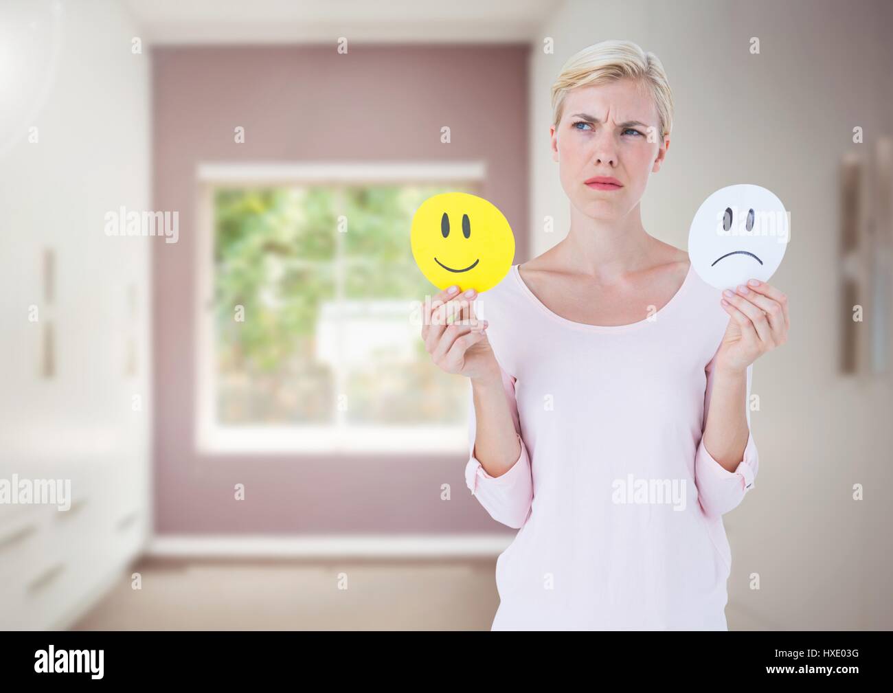 Digital composite of Women holding faces deciding happy or sad emotions ...