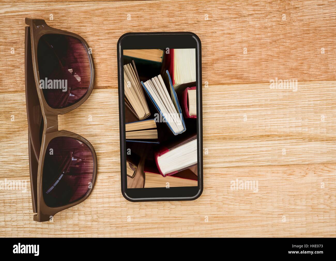 Digital composite of Sunglasses and phone showing standing books Stock ...