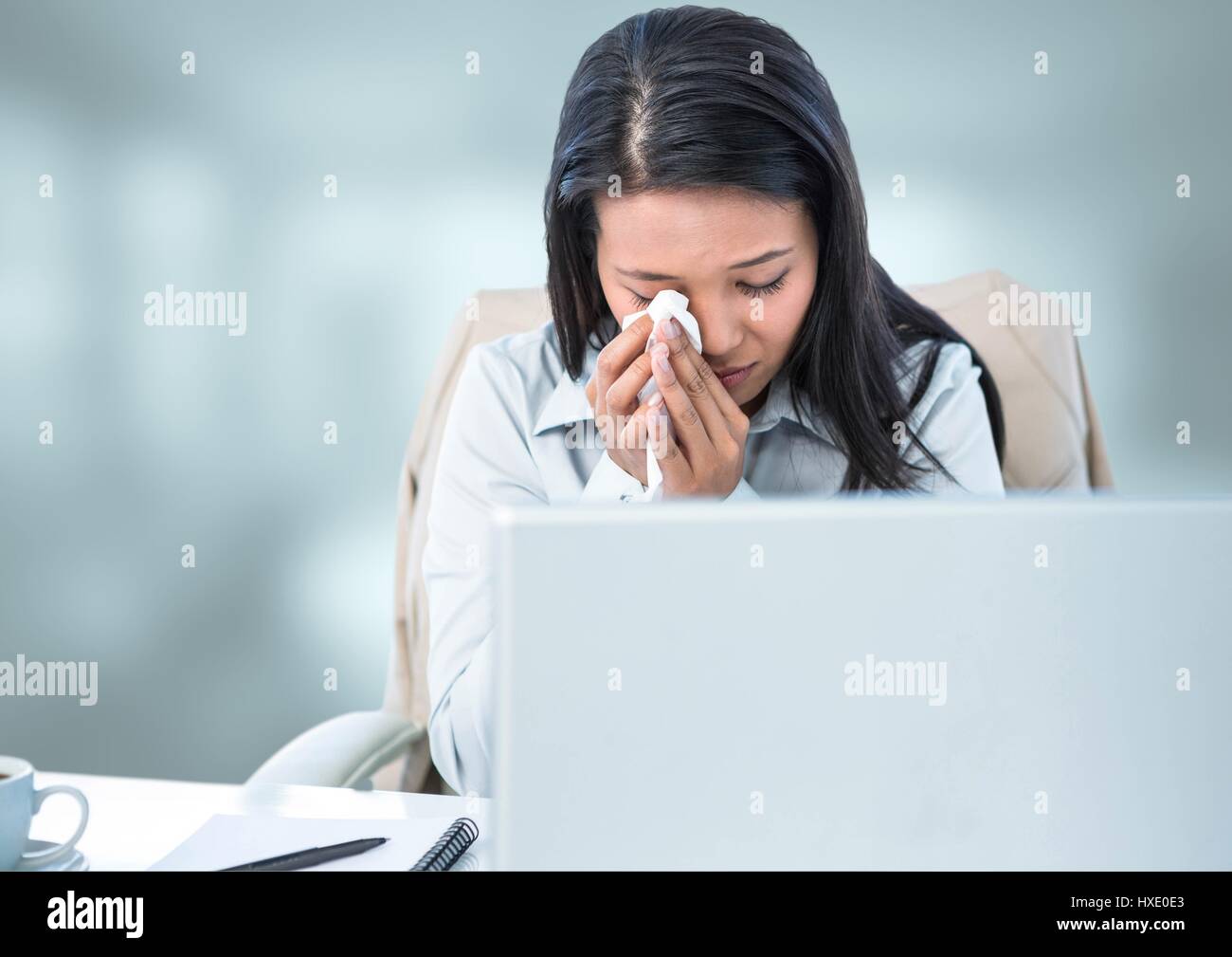 Digital composite of Sad woman crying on laptop with bright background ...