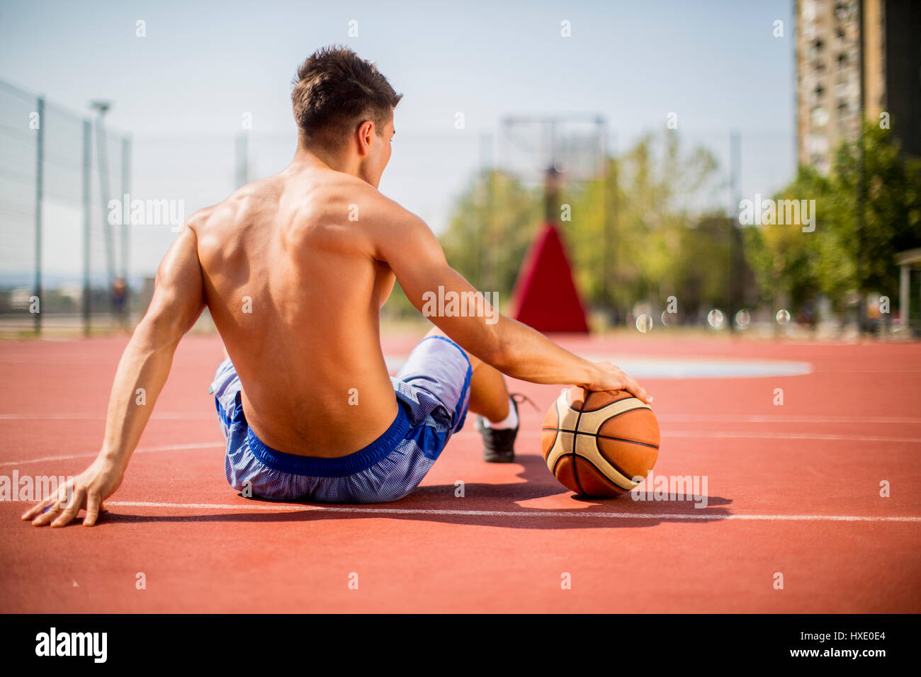 Young man resting from playing basketball Stock Photo - Alamy