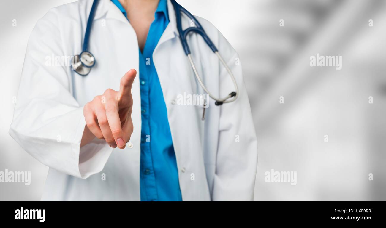 Digital composite of Doctor mid section pointing against blurry ...