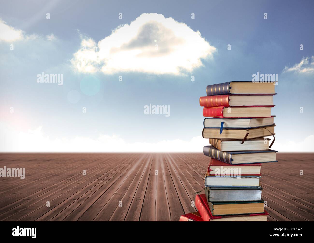 Digital composite of Books stacked by blue cloudy sky Stock Photo - Alamy