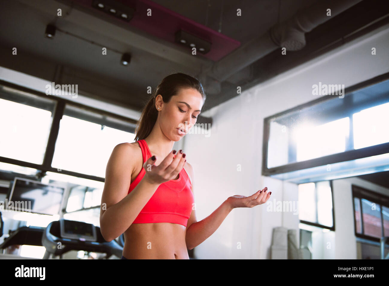 Young woman powder hands before exercise in the gym Stock Photo - Alamy