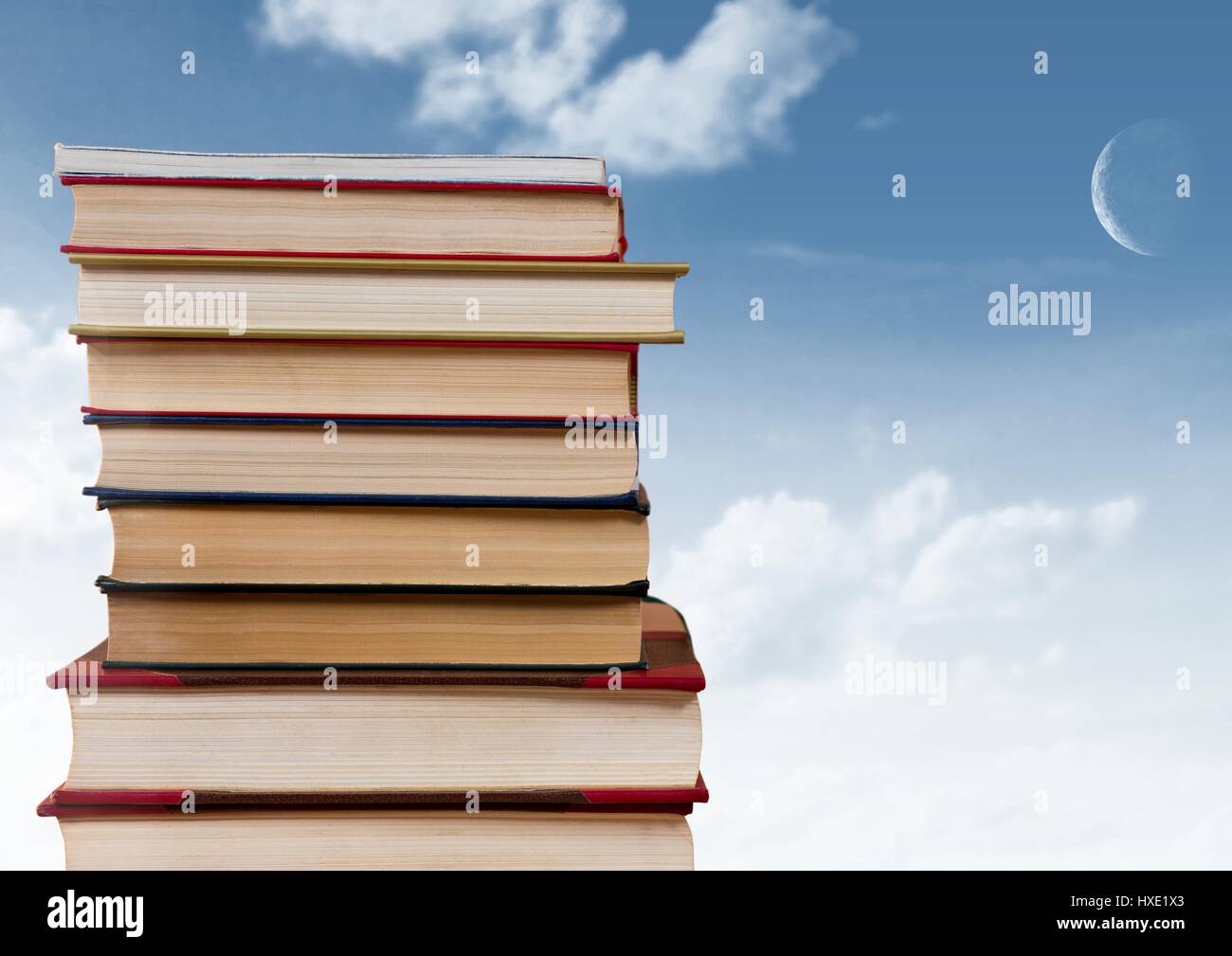 Digital composite of Books stacked by blue sky Stock Photo - Alamy