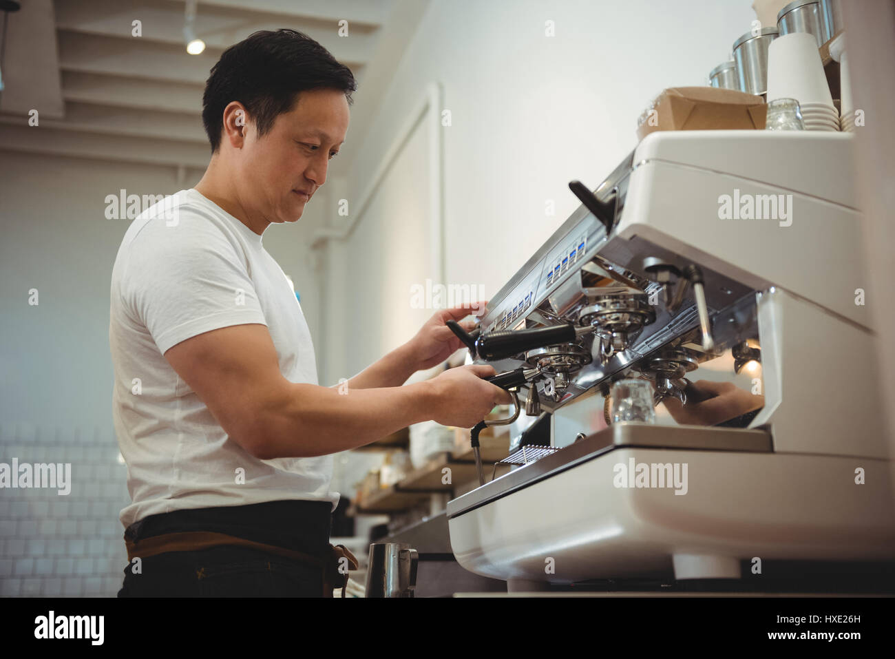 Side view of male barista using espresso machine in cafe Stock Photo ...