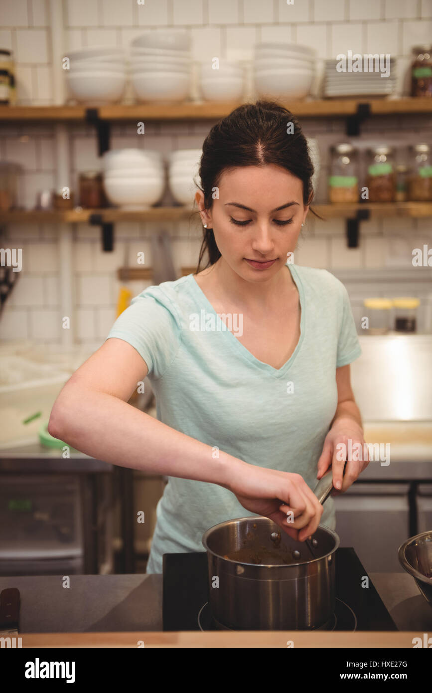 Young female chef cooking food in commercial kitchen Stock Photo - Alamy