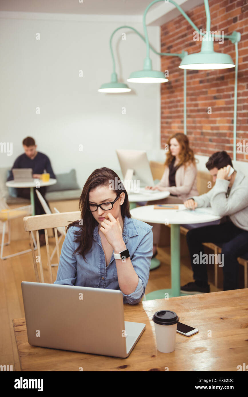 Female executive using laptop at desk in office Stock Photo - Alamy
